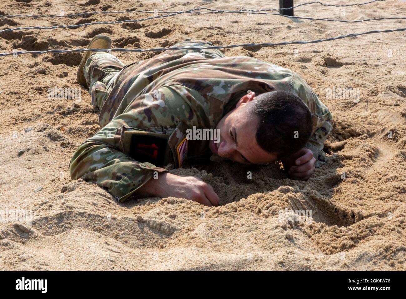 Spc. Daniel Olmedia, an XVIII CORPS Soldier, attacks the low crawl ...