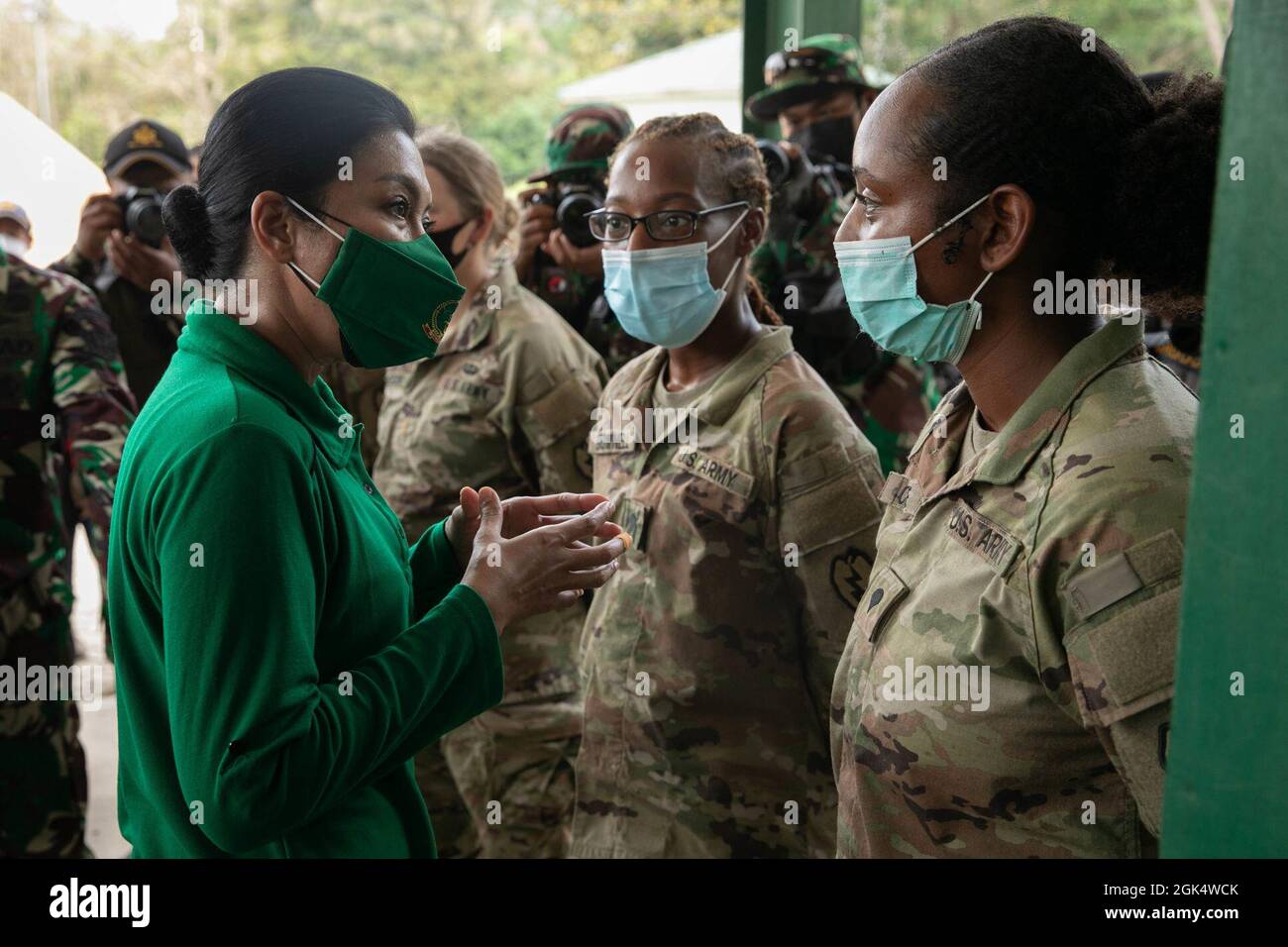 U.S. Army Soldiers, with Task Force Warrior, speak with Diah Erwiany ...