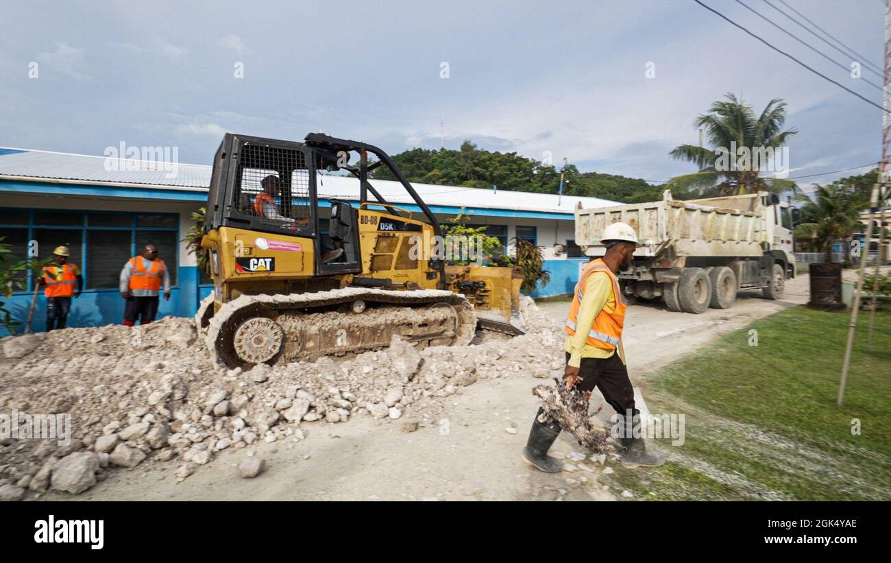 Construction workers with Surangel & Sons Co. work to restore a ...