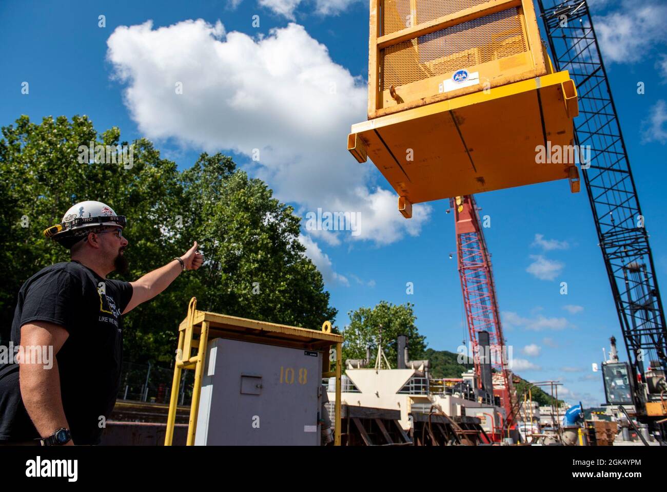 A maintenance operator for the Medium Capacity Fleet signals to a crane ...