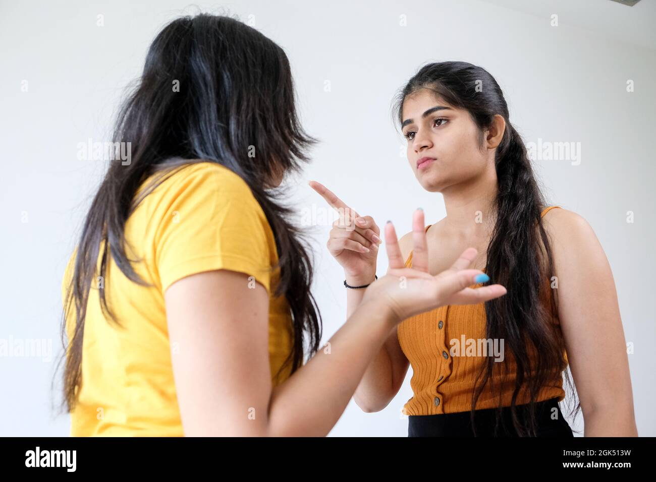 Closeup shot of two girls arguing on a white background Stock Photo - Alamy