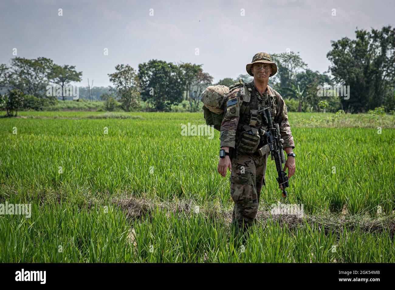 A U.S. Army Soldier with the 82nd Airborne Division stands in a paddy ...