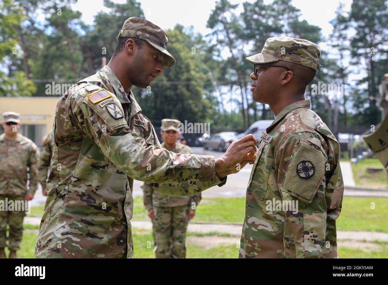 Sgt. Carl Holman (left) promotes his Soldier, Pfc. Jeremiah Harvey ...