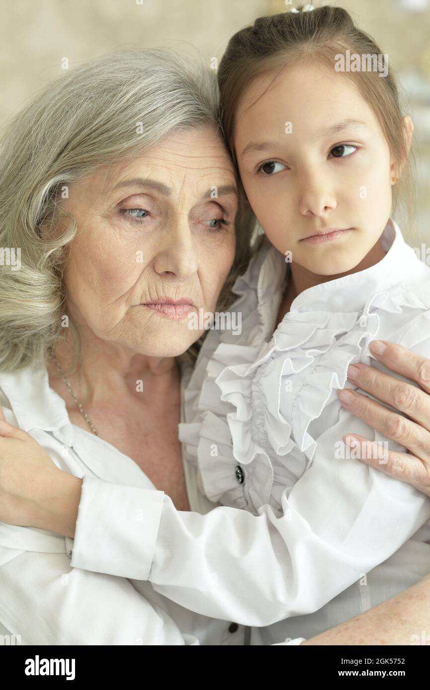 Sad grandmother and granddaughter hugging at home Stock Photo - Alamy