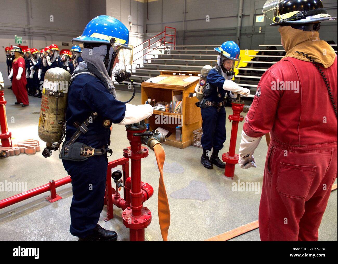 Recruits secure a water valve during a firefighting and damage control ...