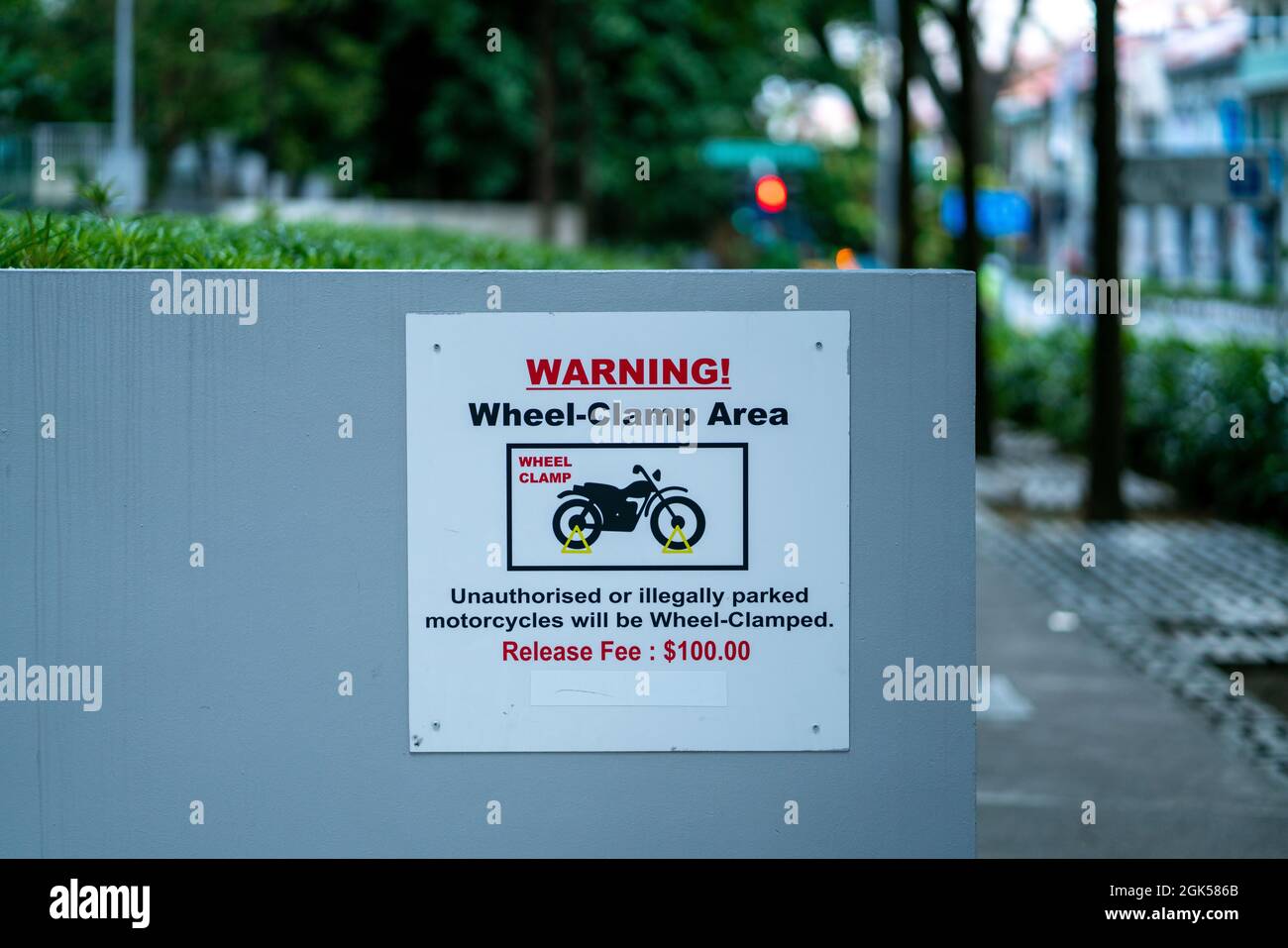 Warning sign , wheel-clamp area, Singapore Stock Photo - Alamy