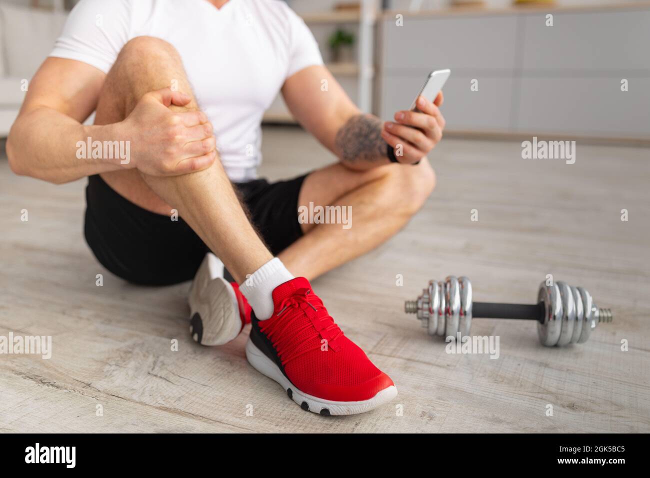 Track activity of body. Mature man with smartphone, sitting on floor ...