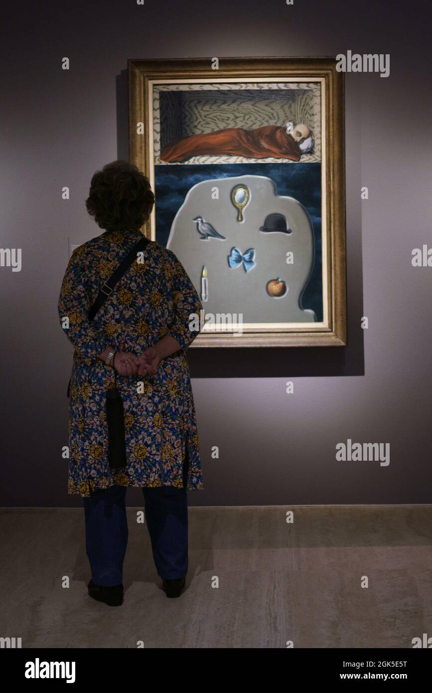 A visitor observes the works of the exhibition "The Magritte Machine ...