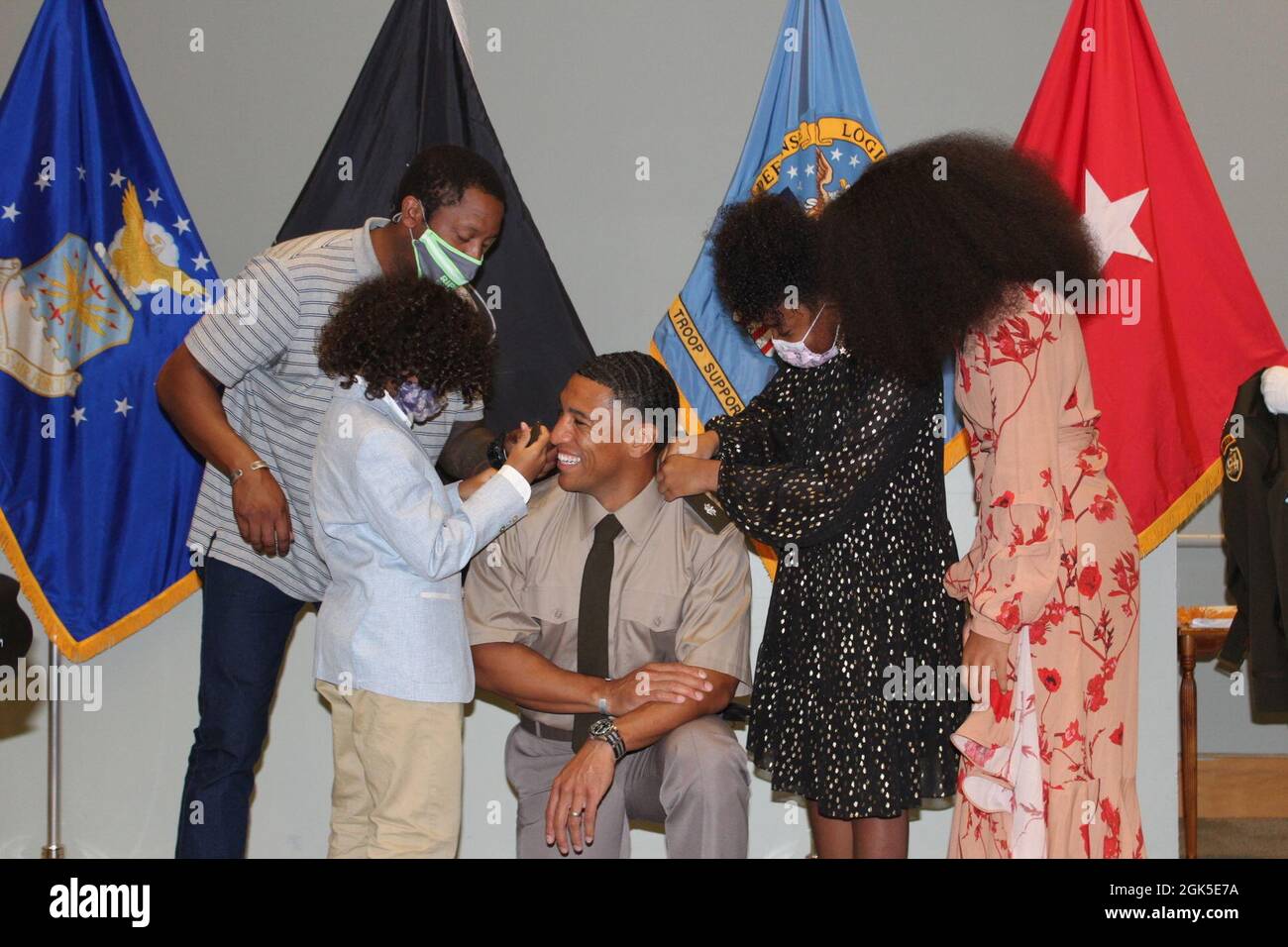 Army Lt. Col. Benjamin Nakamura kneels as his children change his ranks ...