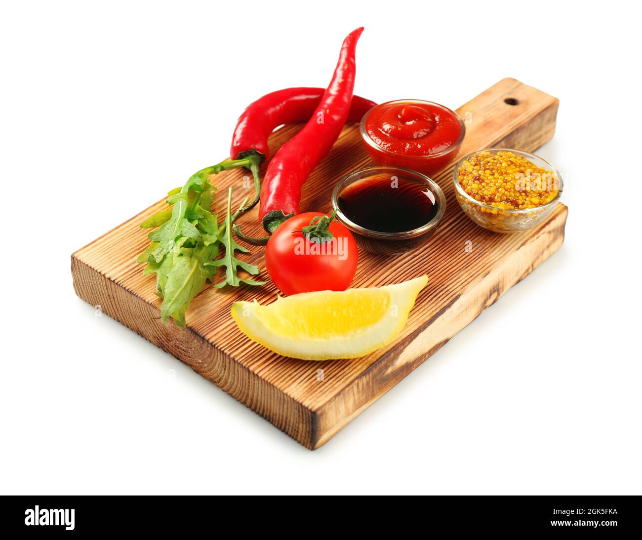 Wooden board with different sauces and vegetables on white background ...