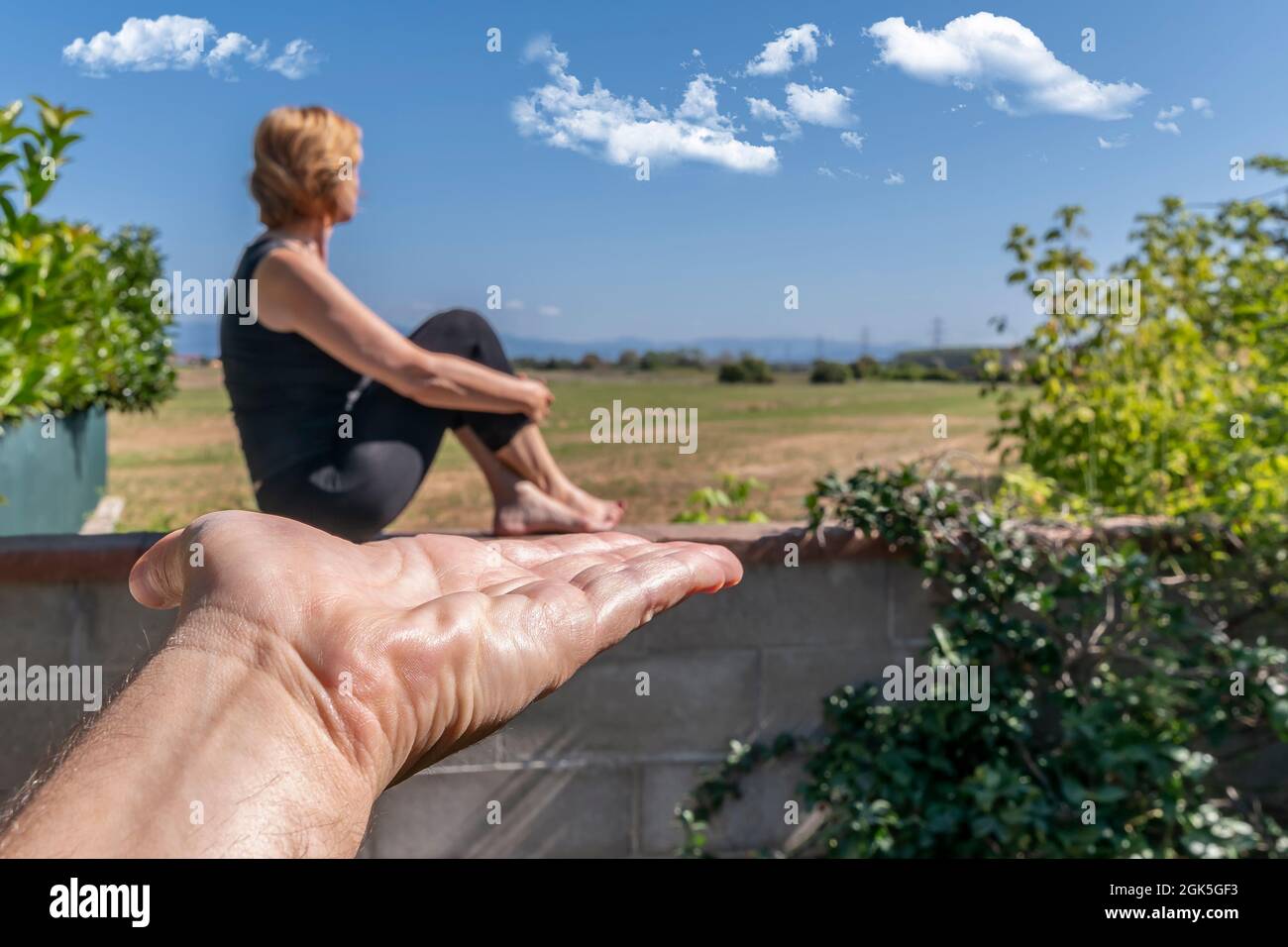 A woman appears to be sitting on a man's hand for a game of perspective ...