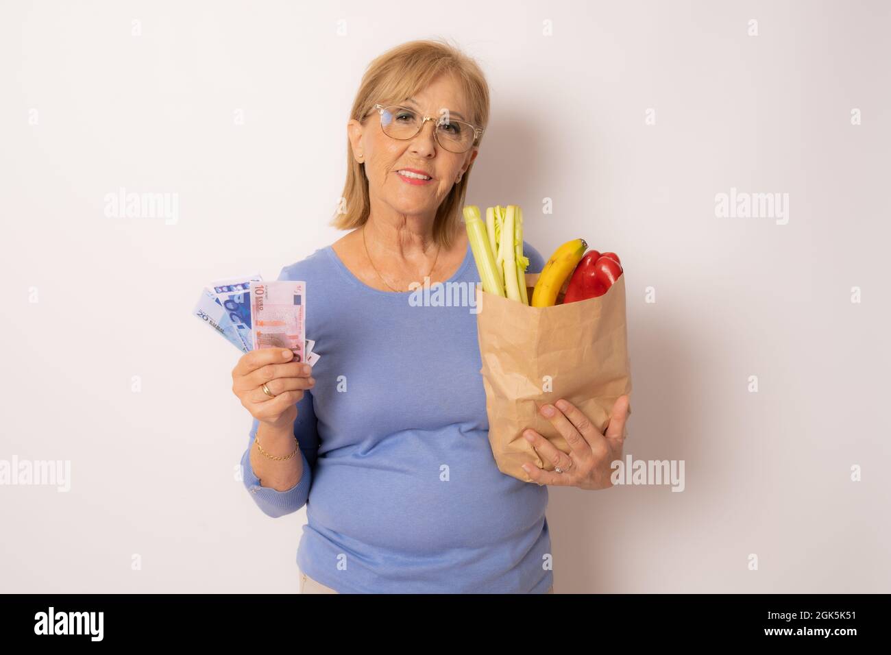Senior shopping woman with grocery items and money . Isolated over white background Stock Photo ...