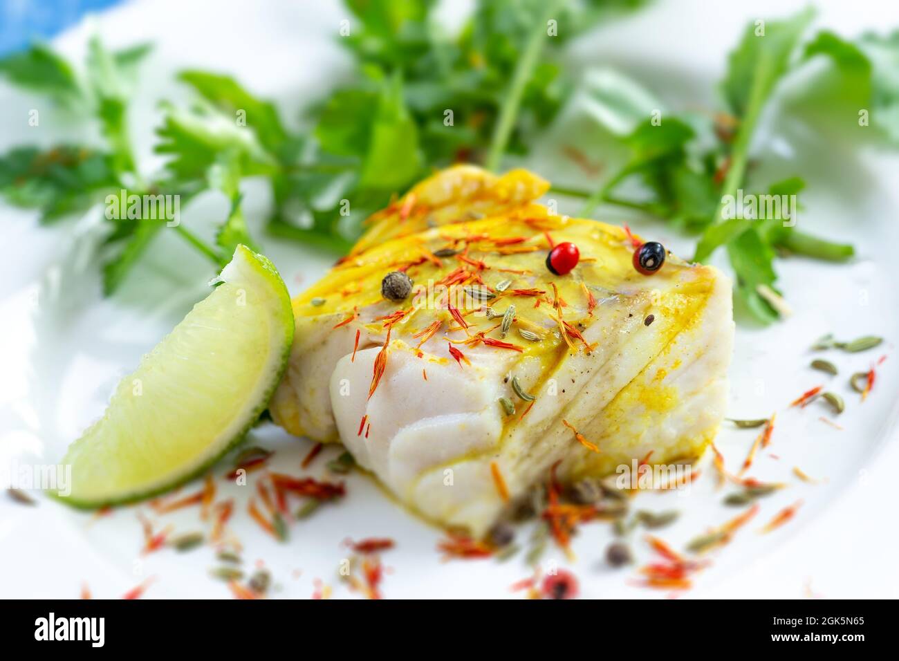 Steamed cod fillet with saffron spice and salad leaves Stock Photo - Alamy