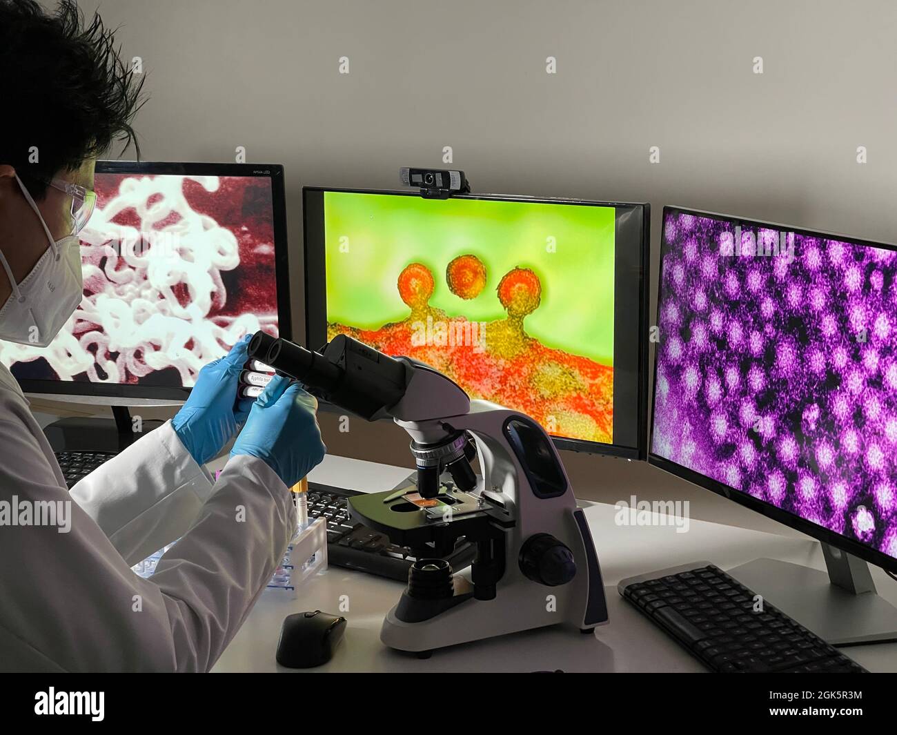 Laboratory technician doing computer research with images of HIV and ...