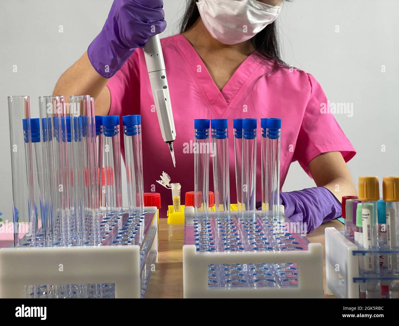 Woman injecting a substance into a tube using a multichannel pipette ...