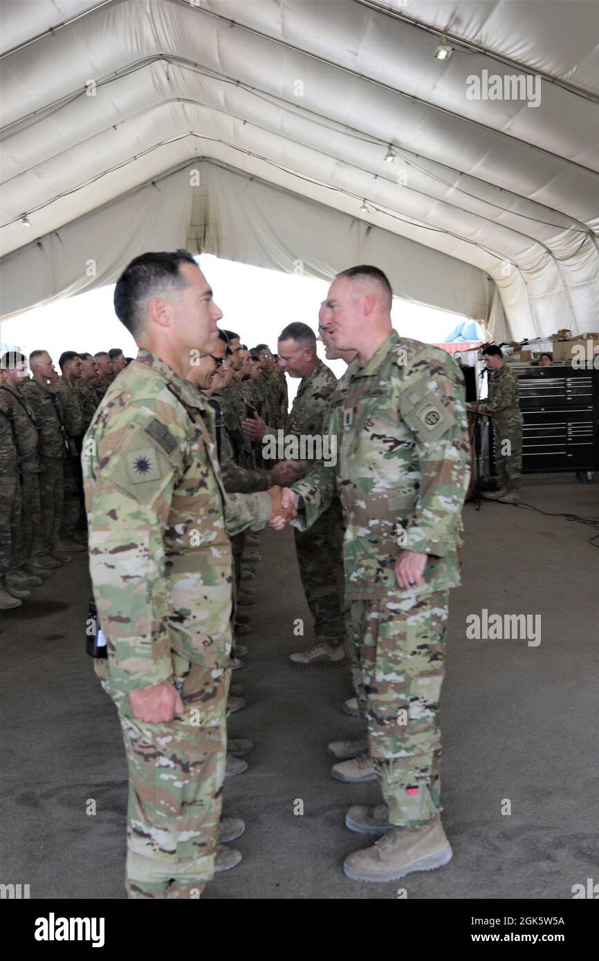 Task Force Wolfpack Command Sgt. Maj. Thomas Coveney congratulates a ...