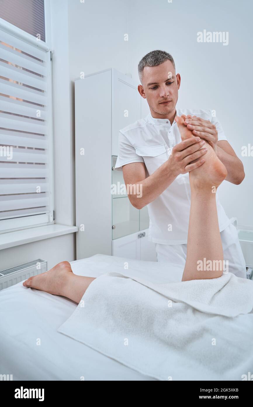 Experienced Concentrated Physiotherapist Using An Acupressure Massage
