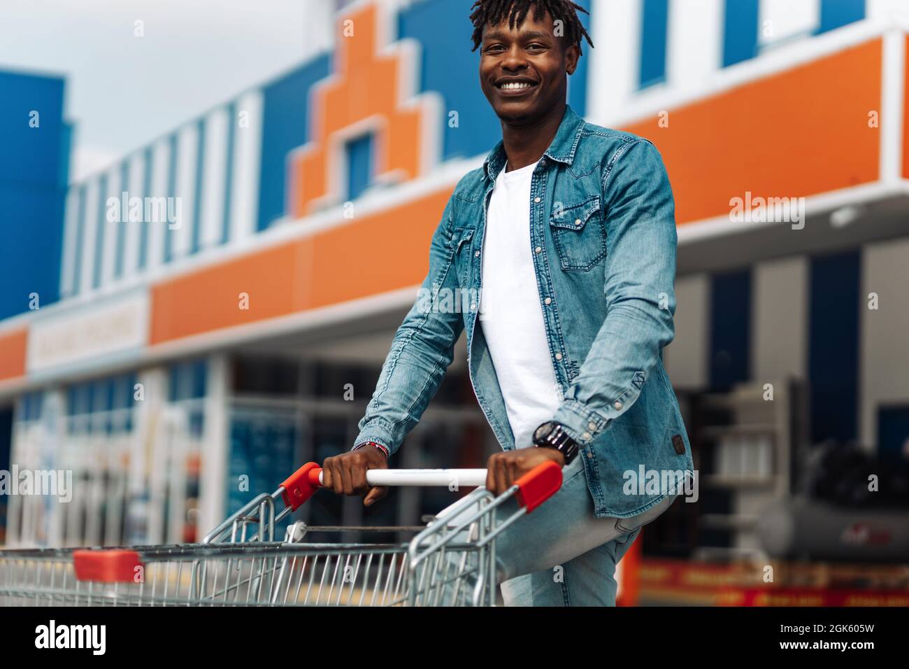 afro american black man with shopping cart in front of mall shopping ...
