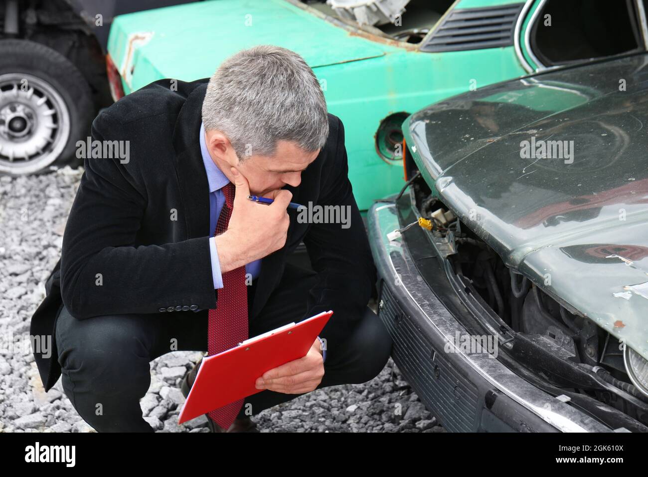 Insurance man checking broken car after accident Stock Photo - Alamy