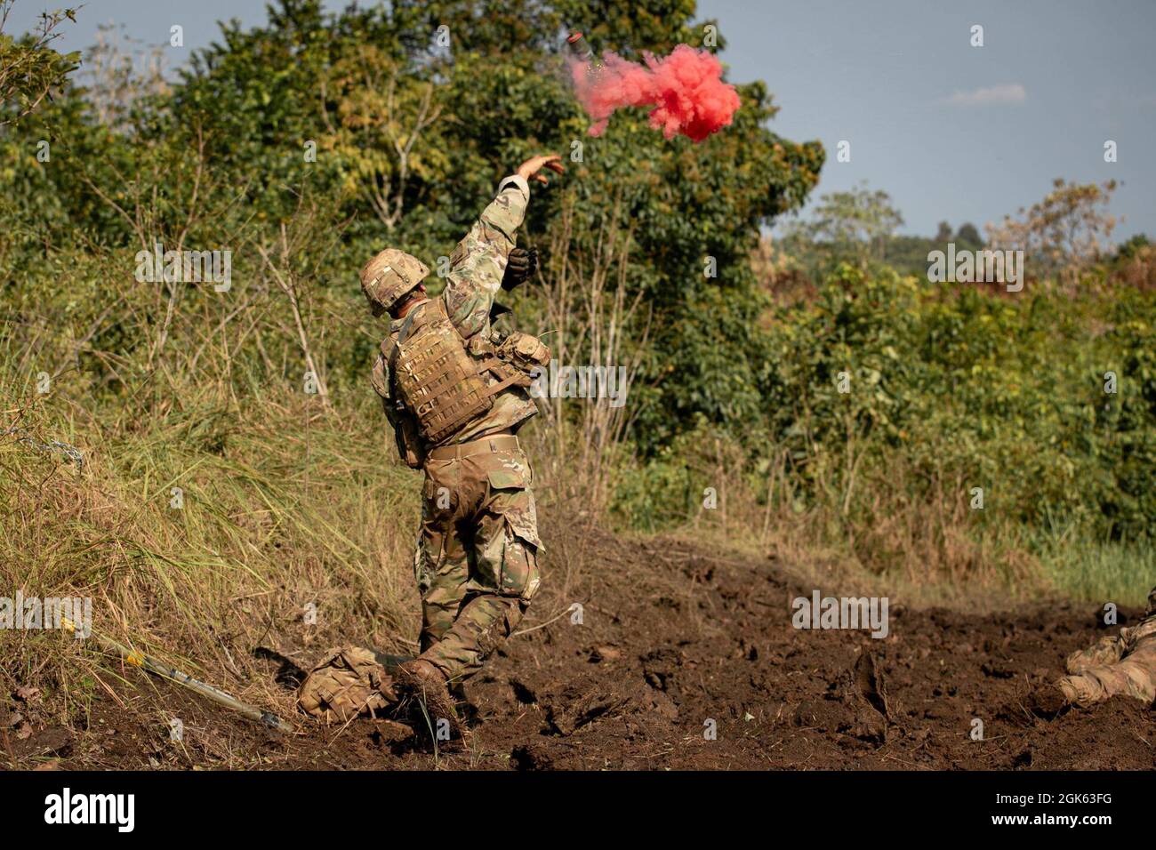 A U.S. Army Soldier with Task Force Warrior throws a red smoke grenade ...