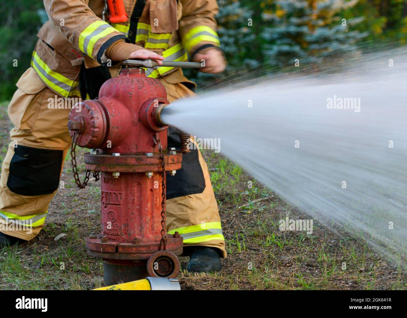 A New York National Guard firefighter uses a wrench to unscrew a fire ...