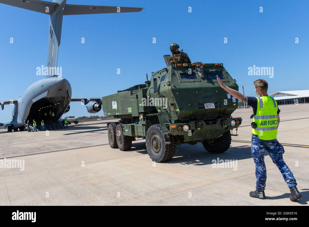 An airman from the Royal Australian Air Force helps guide a U.S. Marine ...