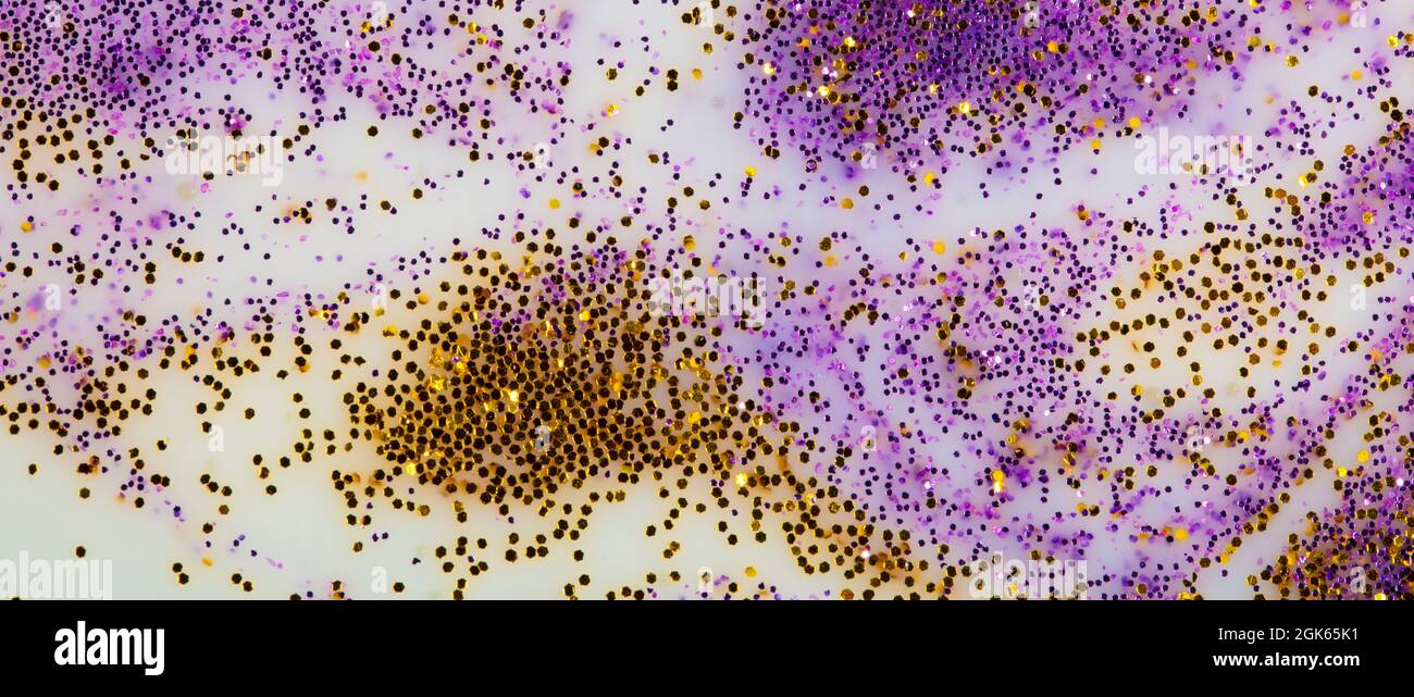 Festive or glamorous background. Gold and purple sparkles scattered on ...