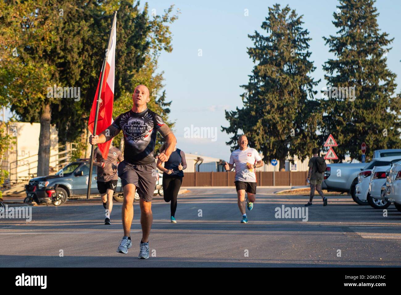 A Polish military member carries the Polish flag to the finish line of ...