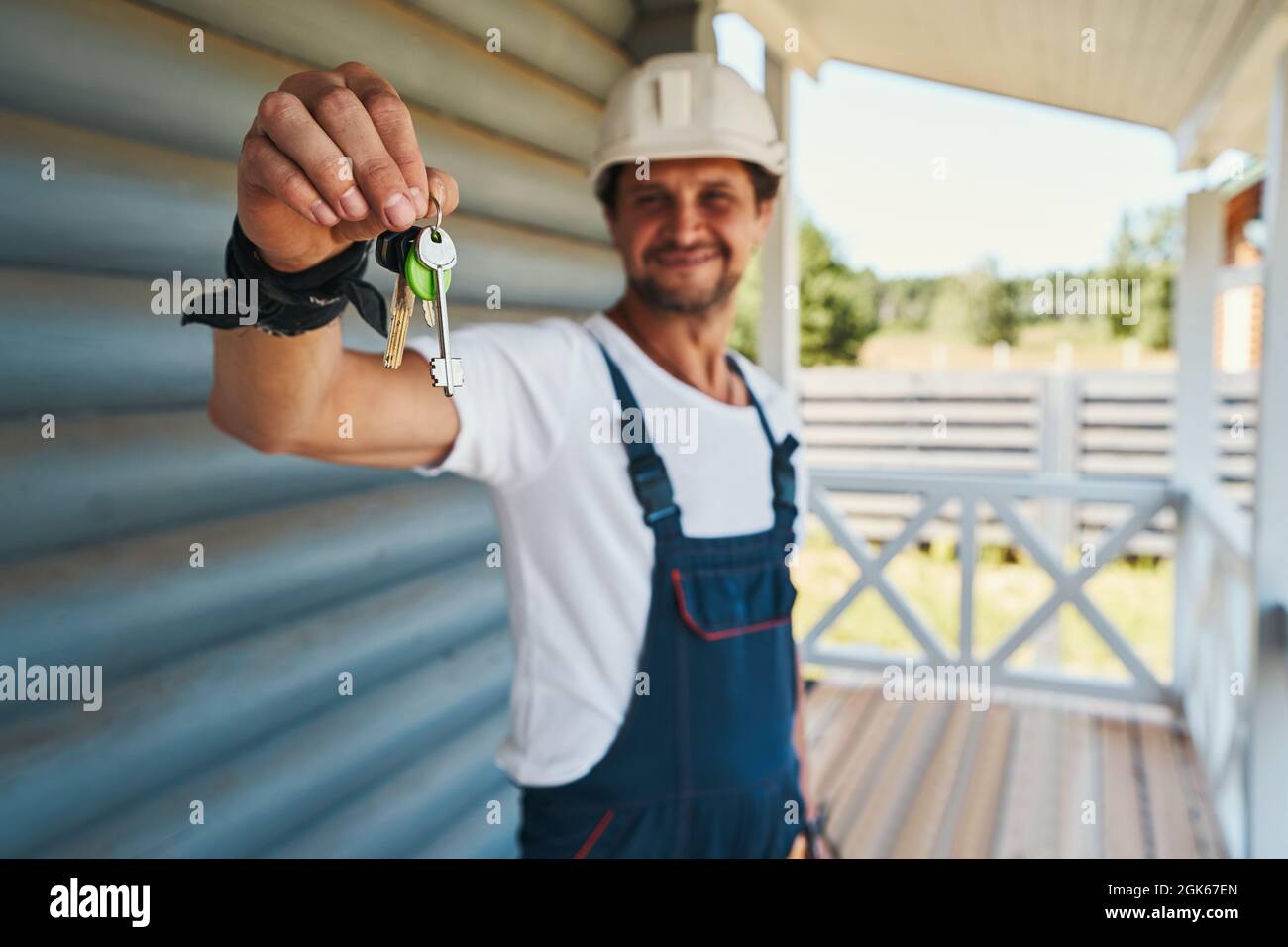 Construction worker handing over keys to house Stock Photo - Alamy