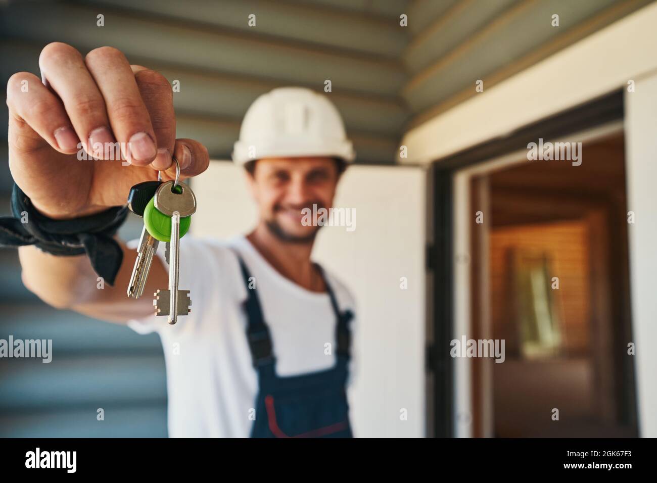 Construction person passing keys to new house Stock Photo - Alamy