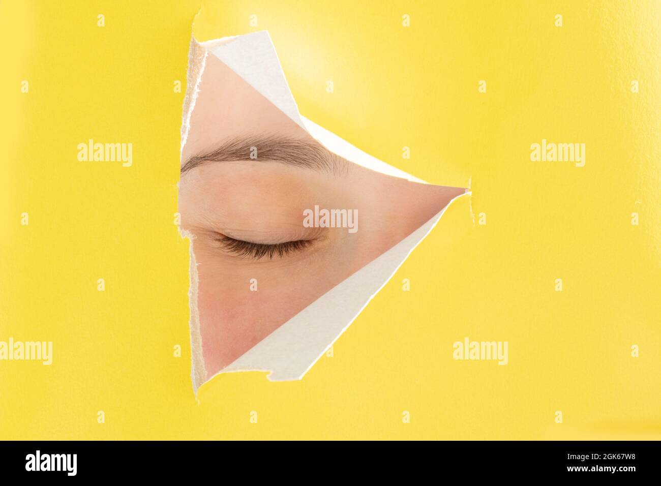 In Yellow paper with a cut out triangle in the middle, a human closed ...