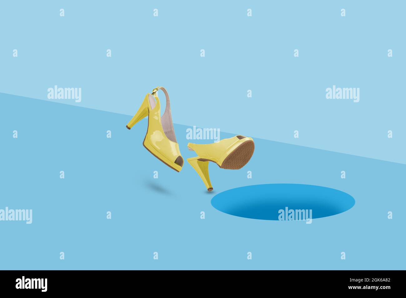 Female yellow high heels shoes in motion falling into dark hole in a ...