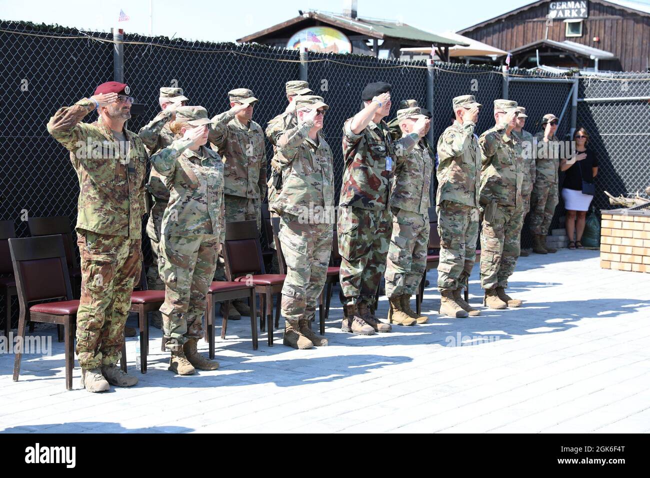 Distinguished guests salute while the National Anthem of the United ...