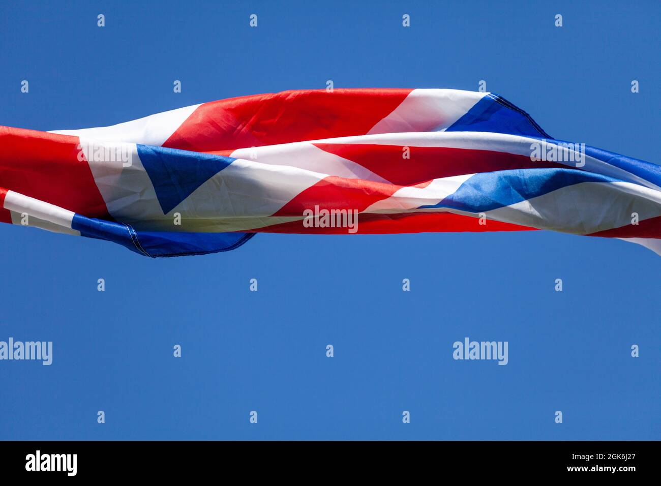 United Kingdom British flag flying in the wind with a blue sky ...