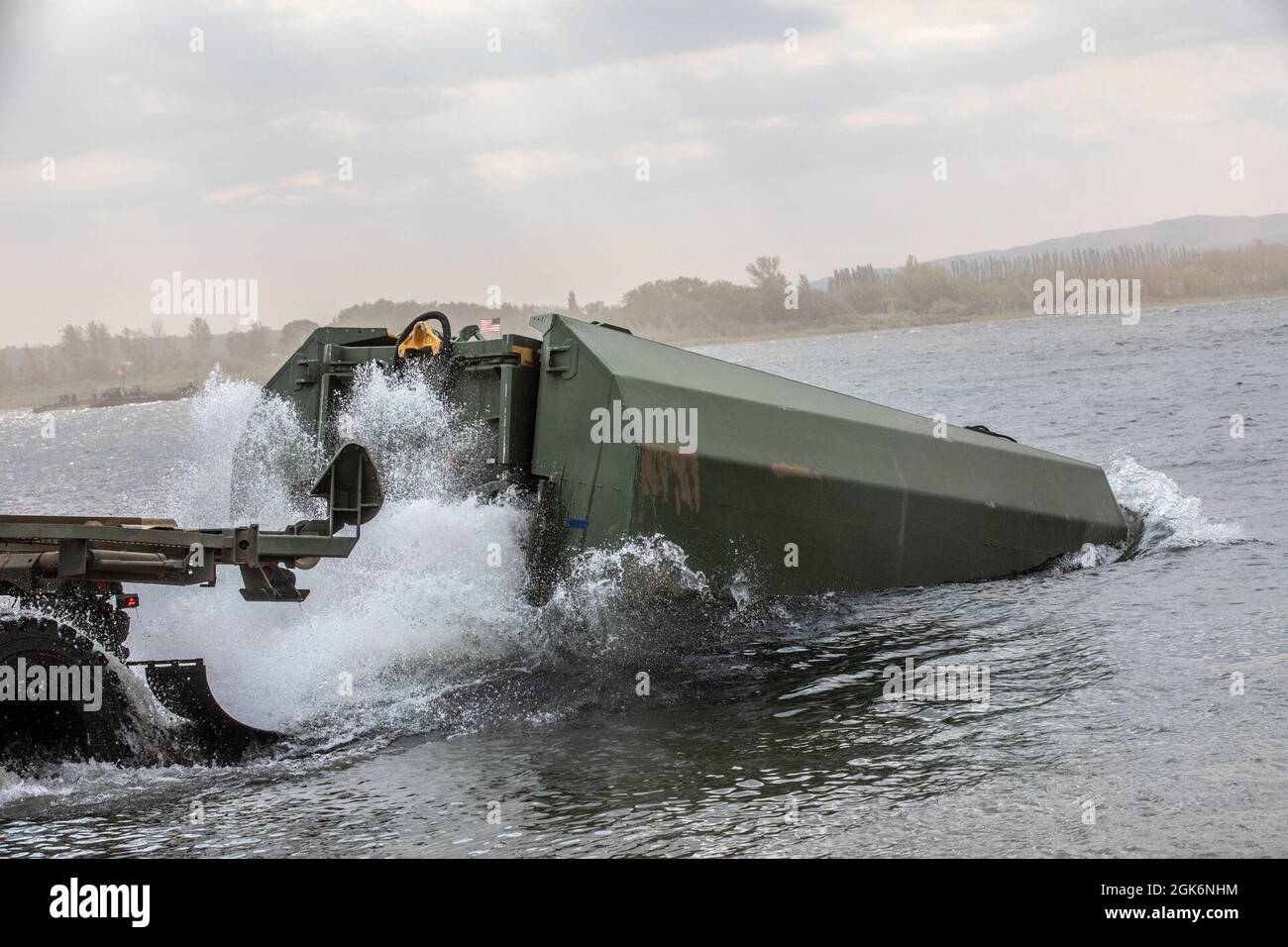 A M1977 Common Bridge Transporter (CBT) drops an Improved Ribbon Bridge ...