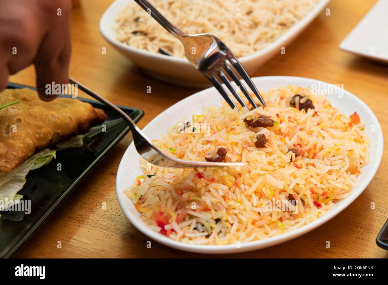 Serving pilau rice from a white tray on a pakistani restaurant table ...