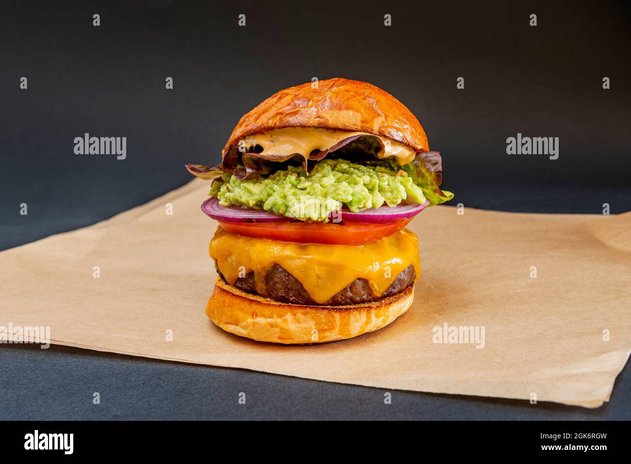 Mexican-style beef burger with melted cheddar cheese, ripe tomato ...