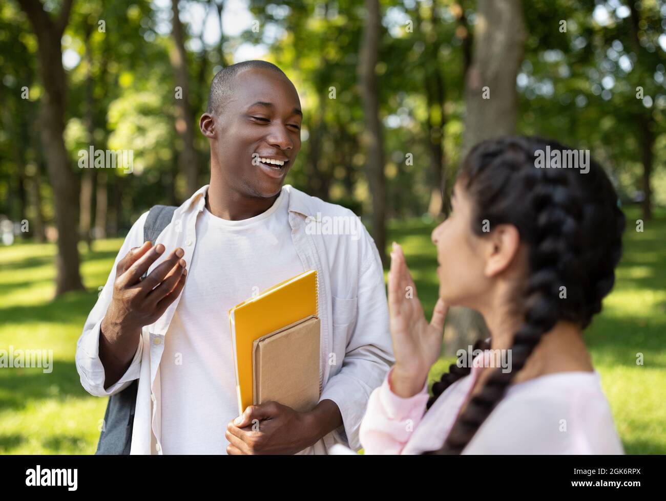 College friendship. Two international students chatting outdoors after ...