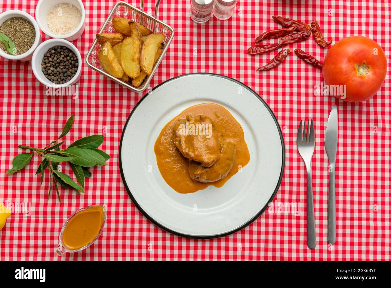 cheeks in Spanish-style sauce accompanied by French fries. Background ...