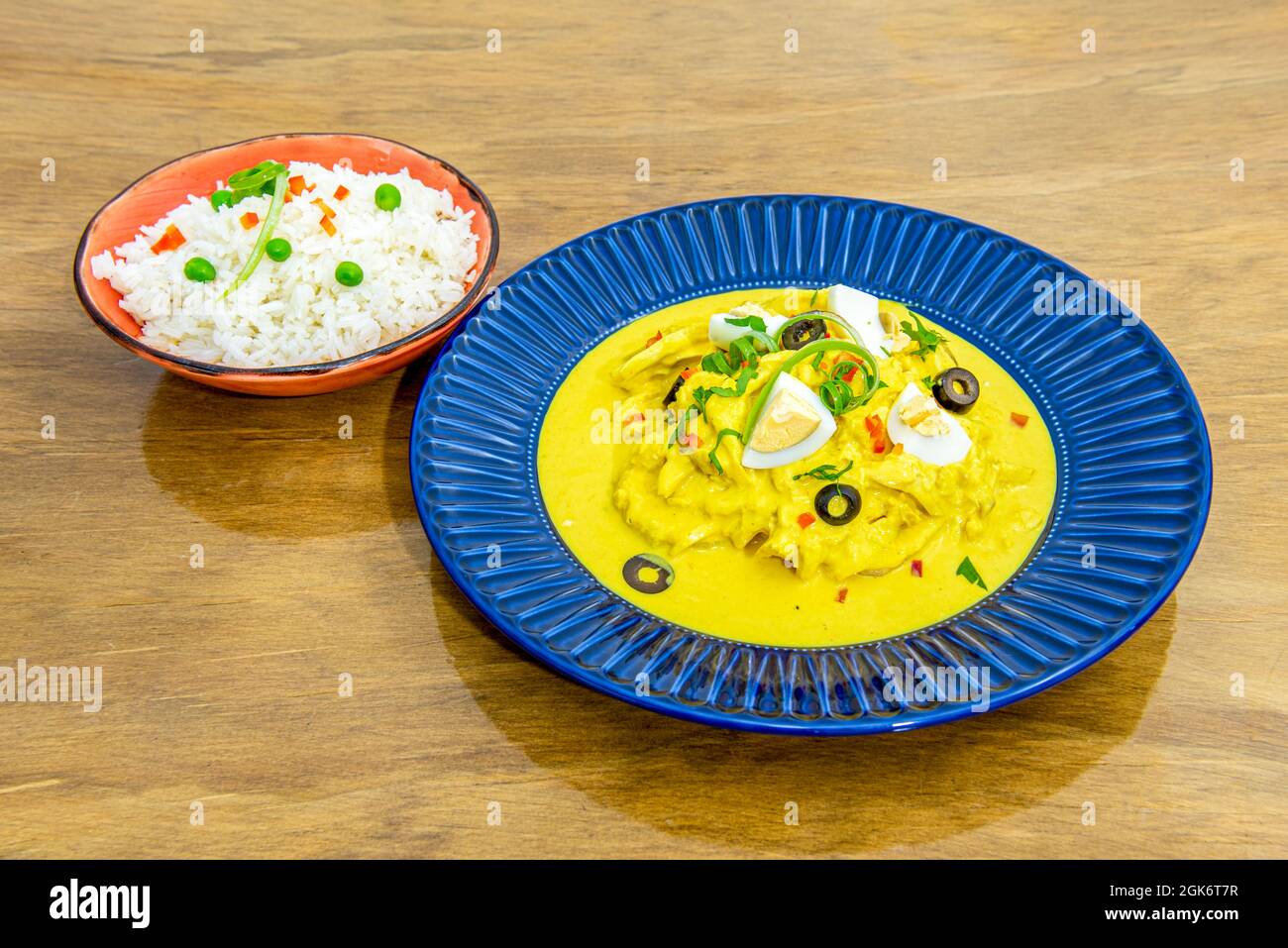 aji de gallina with boiled eggs and rice garnish with peas served in ...