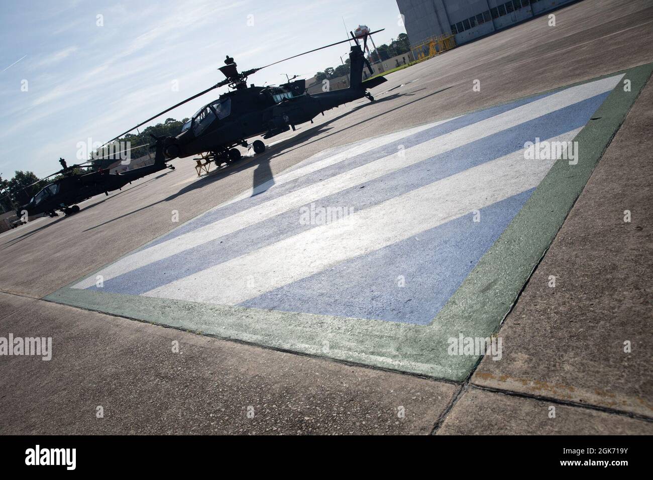 AH-64E Apache helicopters sit outside of the hangars at Hunter Army ...