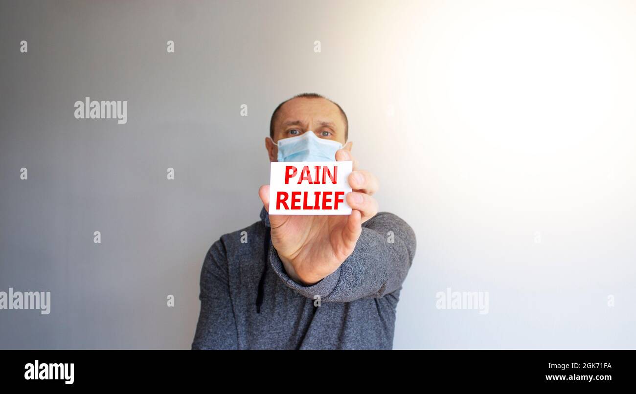 Pain relief symbol. White card, words Pain relief. A young man in a ...