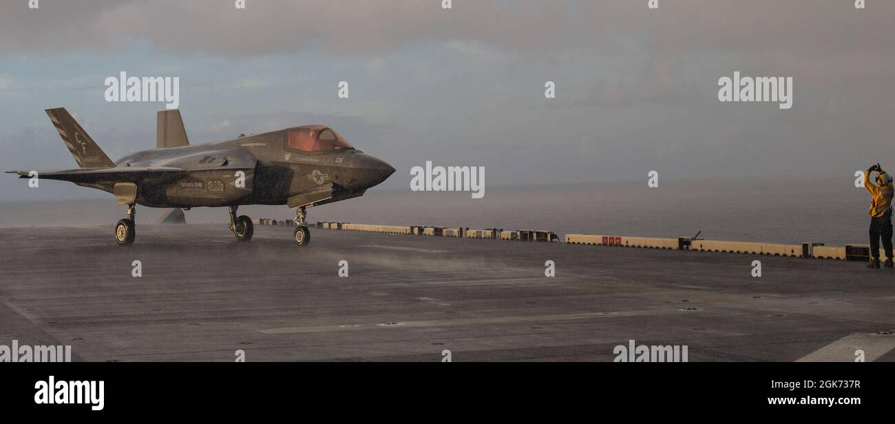 A U.S. Navy Boatswain Mate Handler ground guides a U.S. Marine Corps F ...