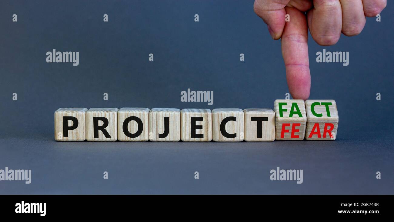 Project fact or fear symbol. Businessman turns cubes, changes words ...