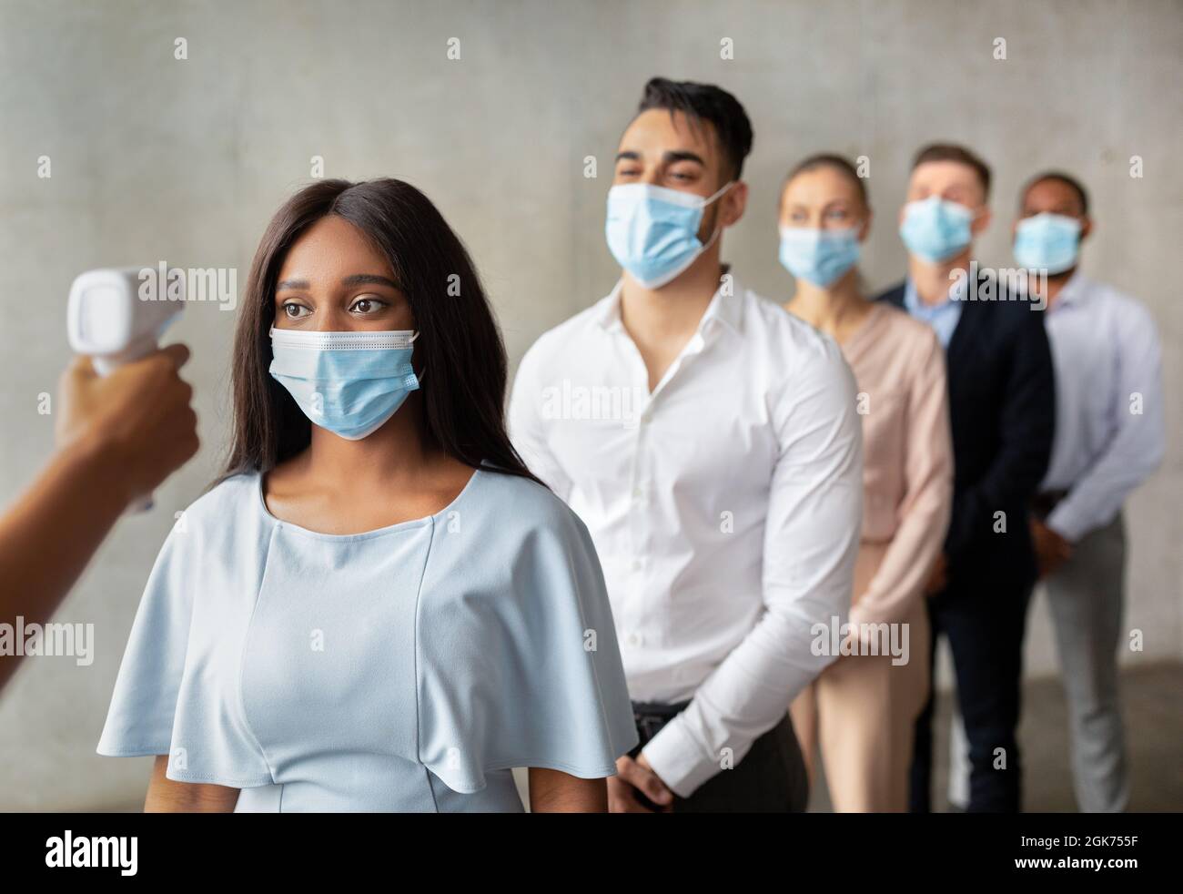 Person With Contactless Thermometer Checking Temperature For Group Of ...