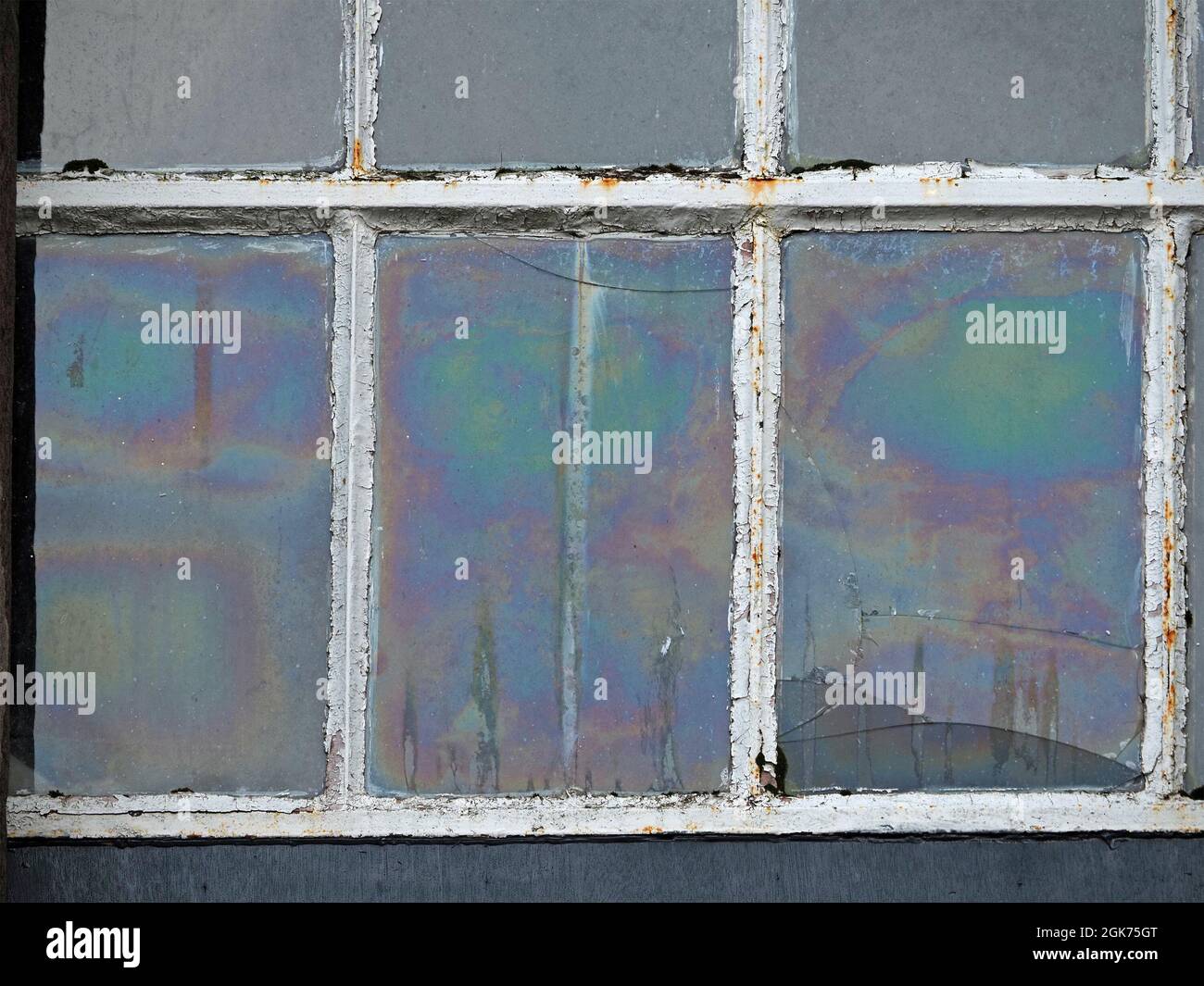 prismatic colours on old glass of farmhouse window with broken panes ...