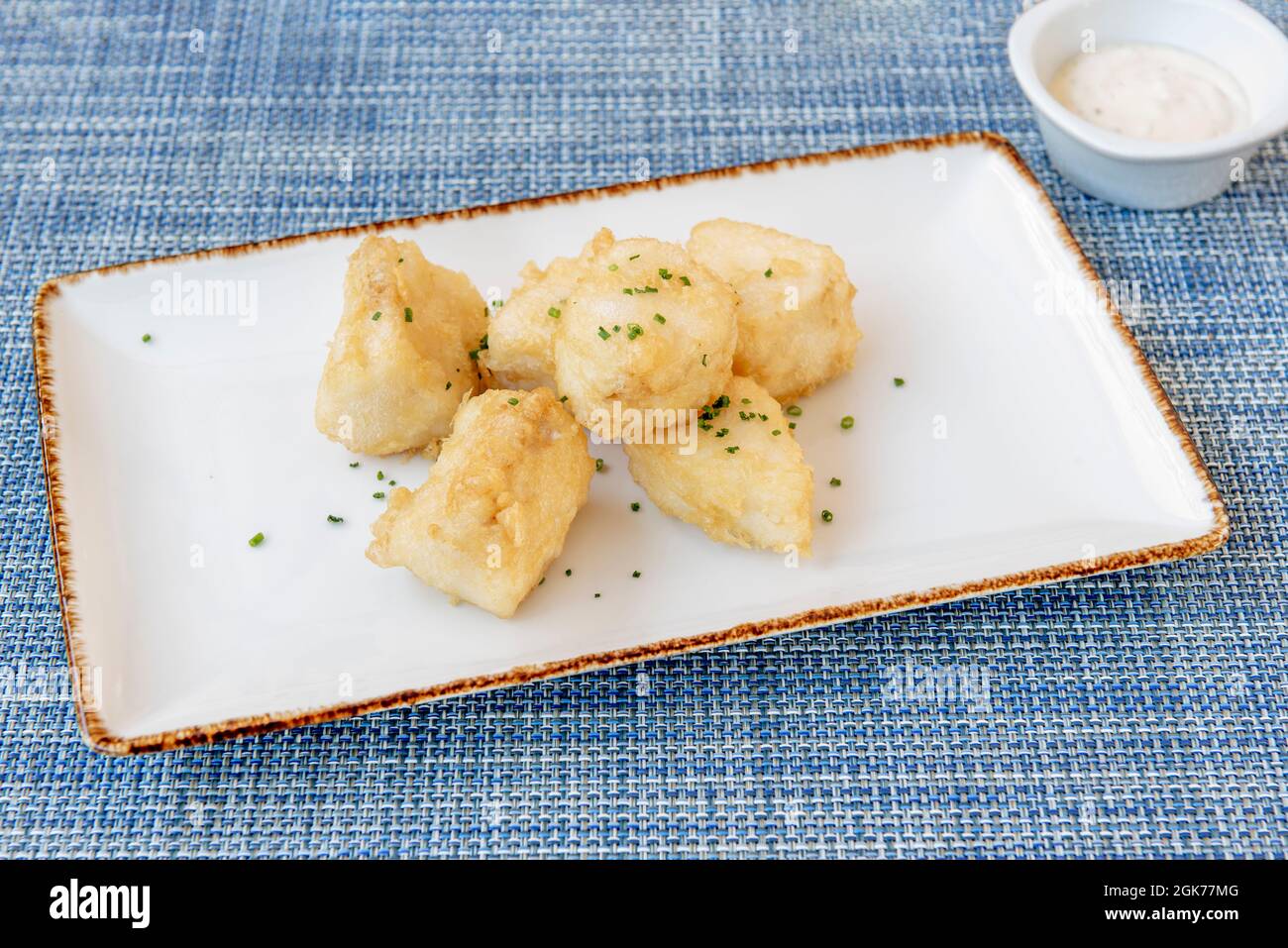Spanish tapa of battered cod tacos with accompanying sauce and garnish ...