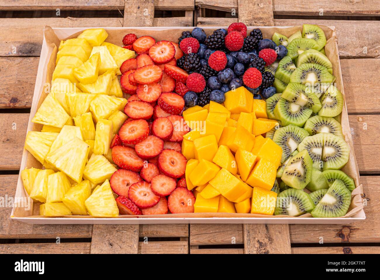 large tray of chopped assorted fruits with pineapple, mango, kiwi ...
