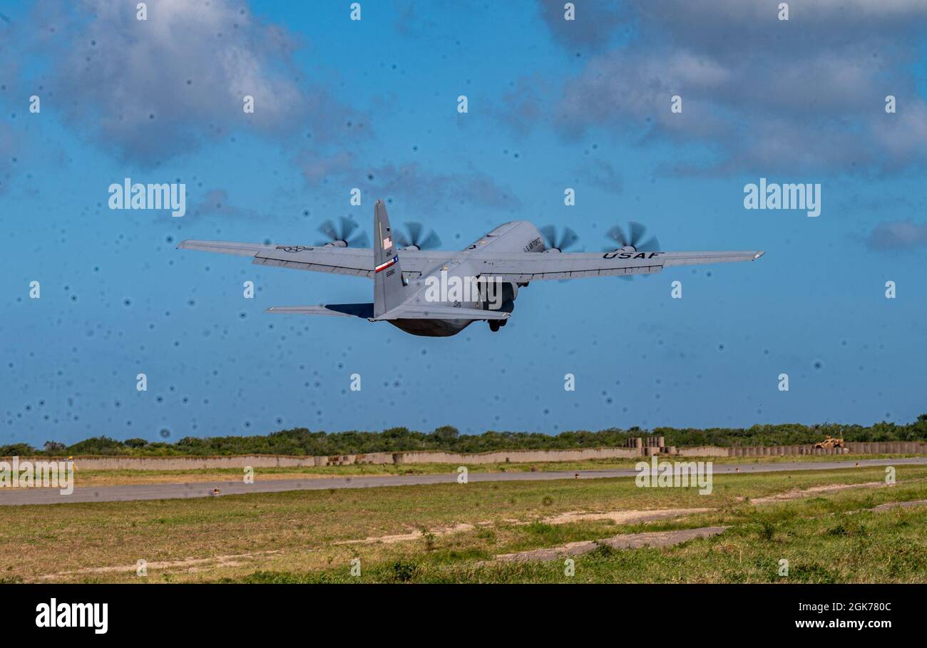 A C-130 Hercules cargo aircraft kicks up debris as it takes off from ...