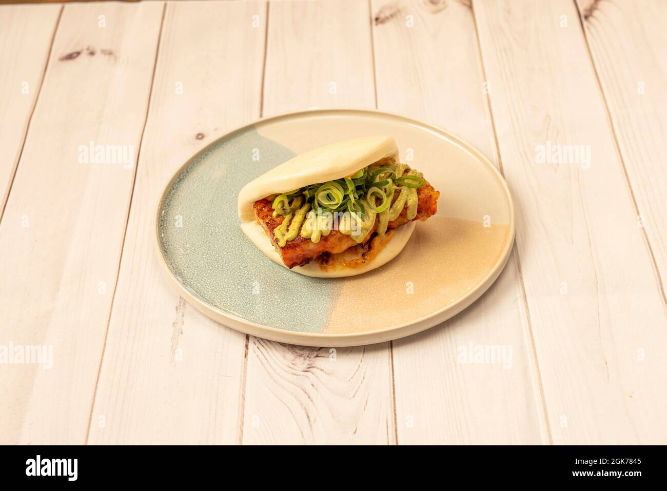 bao stuffed with tiger prawn pastilla with sauce and vegetables Stock ...